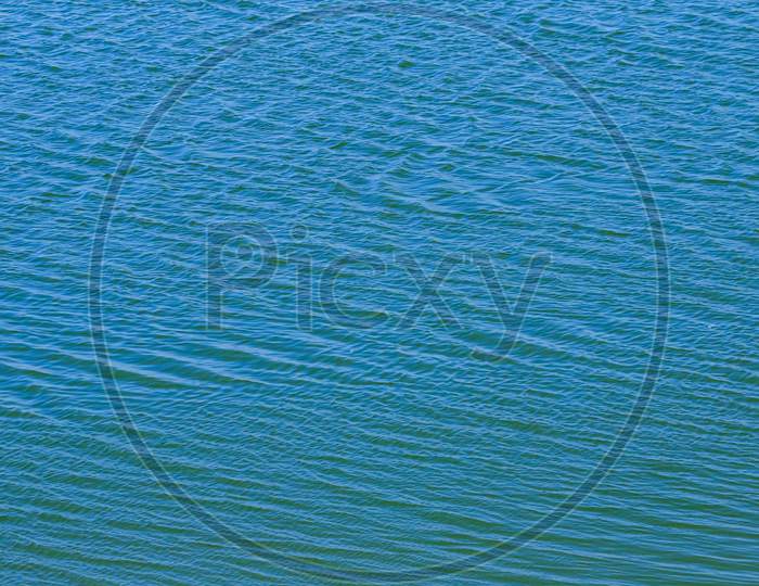 Image of A grainy abstract image of ripples on blue water creating a ...