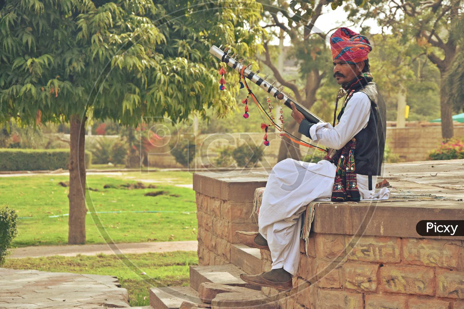 Image of Gypsy musician playing tumbi instrument-DG278737-Picxy