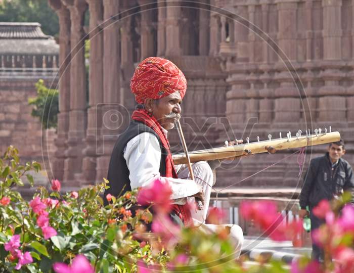Image of Gypsy musician playing tumbi instrument-DG278737-Picxy