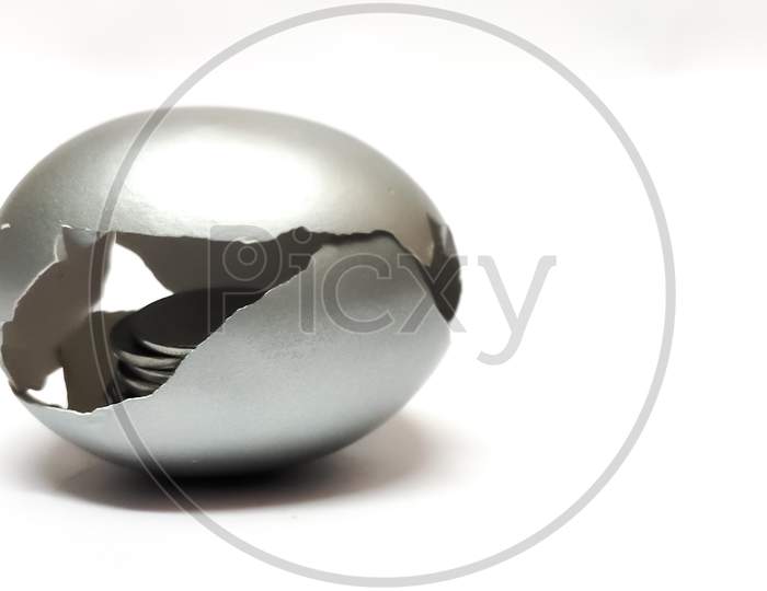 Image of Closeup of Broken silver egg with coins inside isolated in a ...