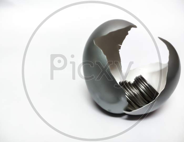 Image of Closeup of Broken silver egg with coins inside isolated in a ...