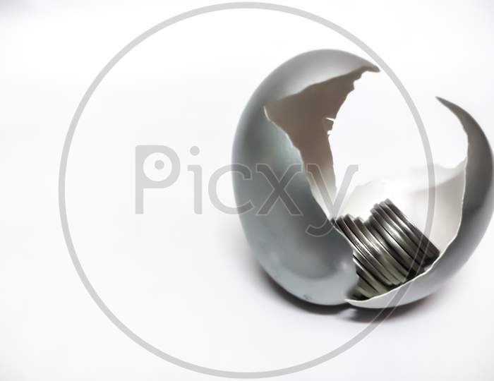 Image of Closeup of Broken silver egg with coins inside isolated in a ...