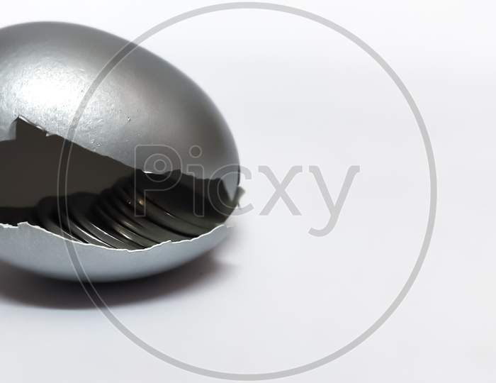 Image of Closeup of Broken silver egg with coins inside isolated in a ...