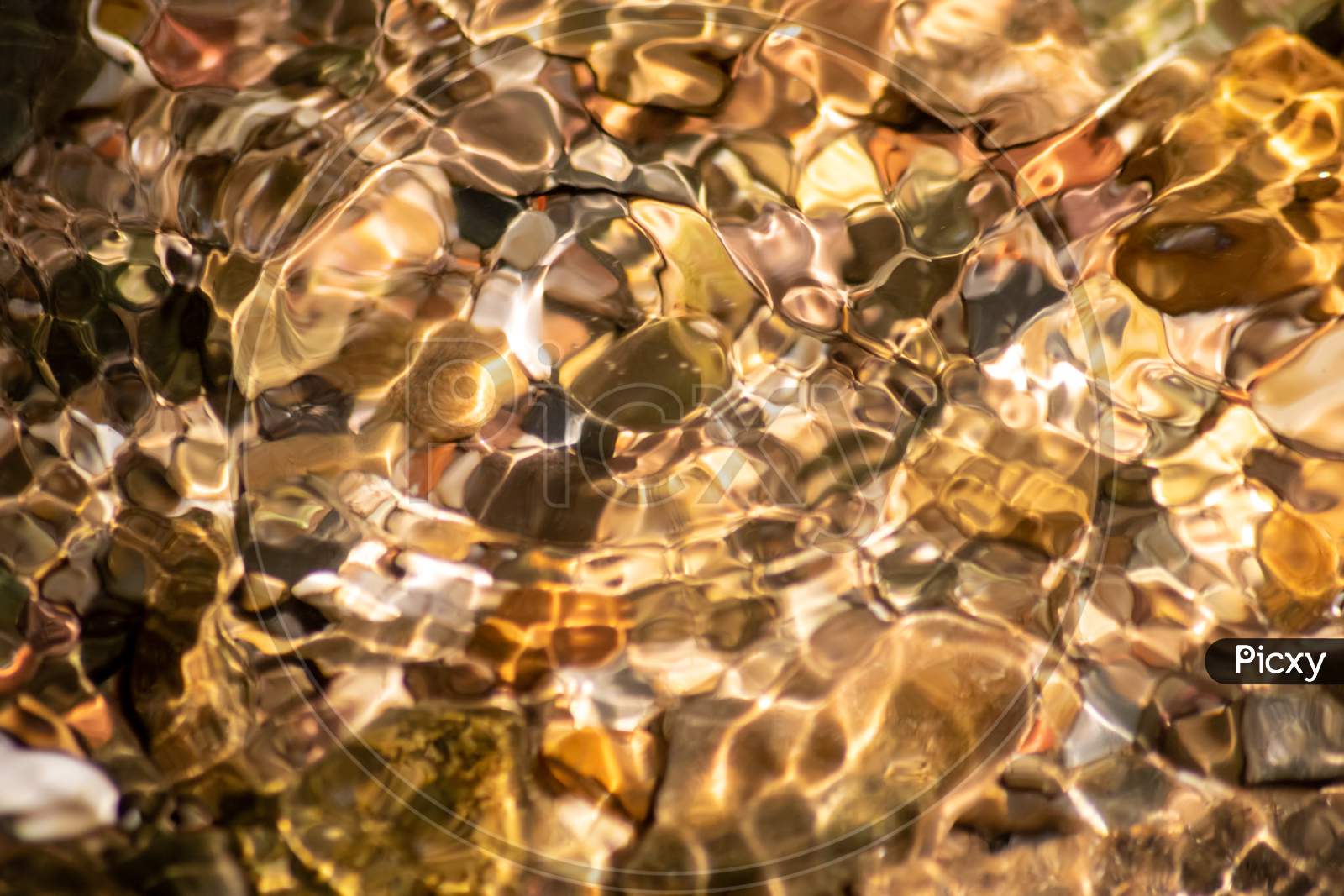 Image of Stones in sparkling water with sunny reflections in water of a ...