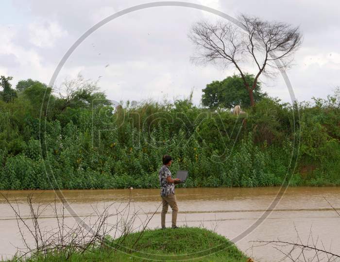 Image of Stylish Boy Holding Laptop Computer Around Natural Sky Background With Tree Without ...