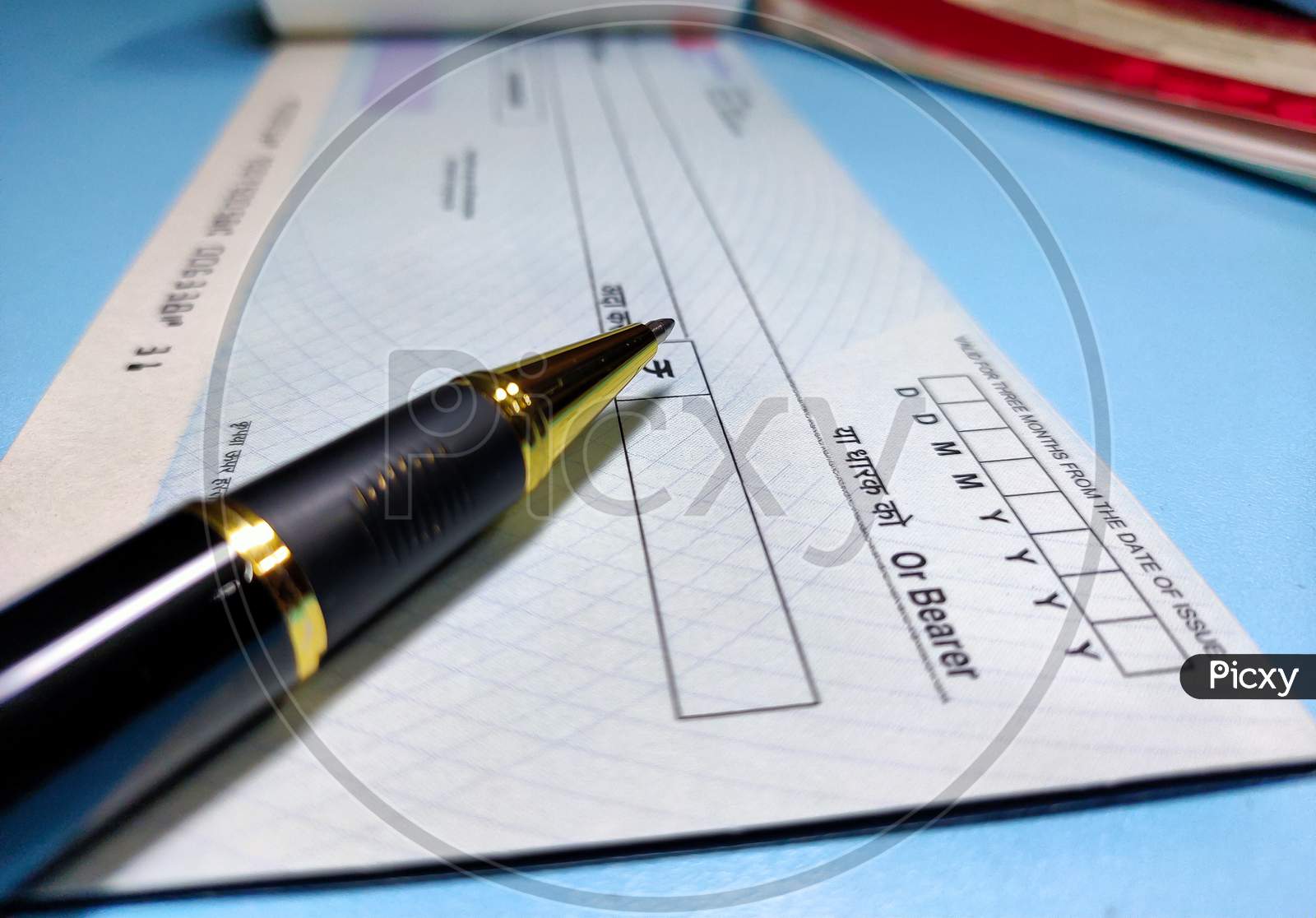 Image of Blank Cheque Leaf With Pen Kept On Desk.-DD087342-Picxy