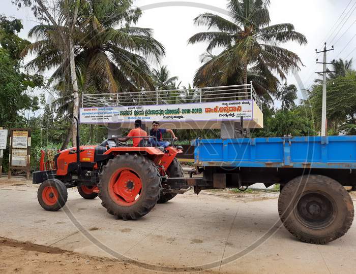 Image of Closeup Of Tractor Moving In Front Of The Village Bus Stop At ...