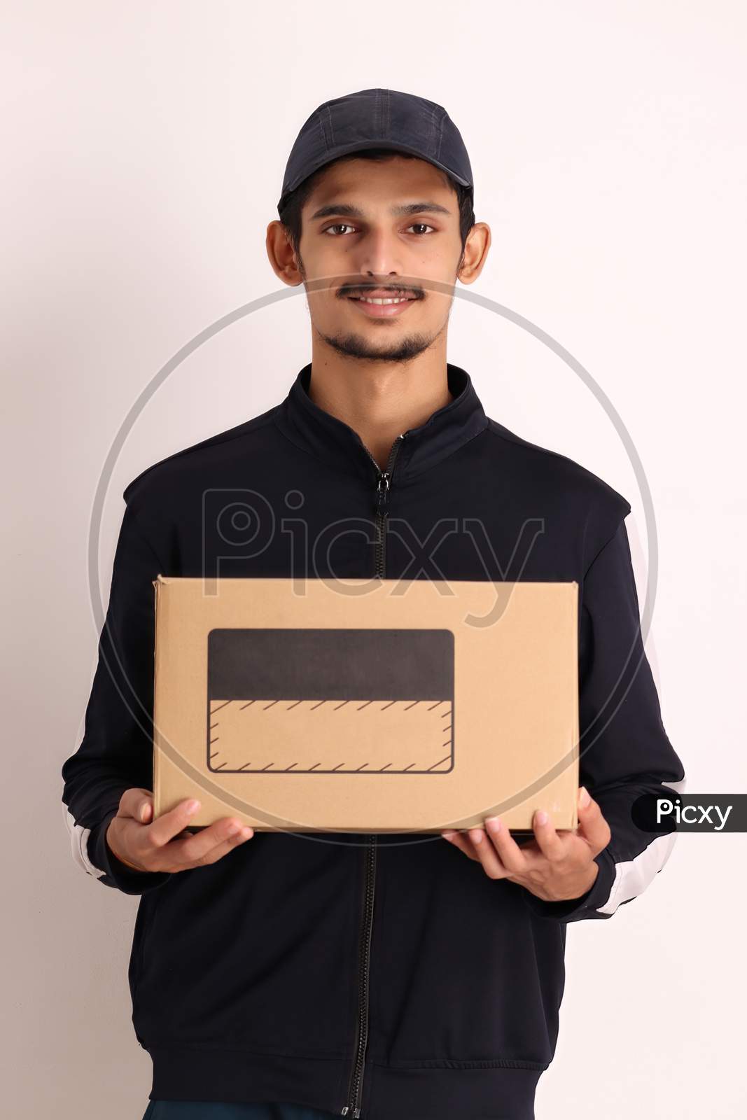 Image of unshaven Indian courier boy with brown box wearing black t ...